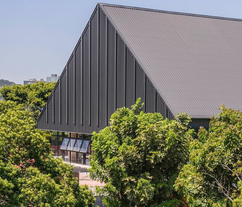 triangular metal roof crowns elevated sports hall in taiwan school ...